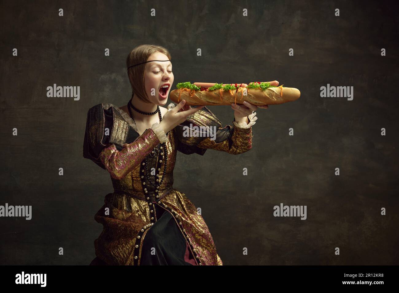 Portrait of young girl, princess in vintage costume eating giant ...