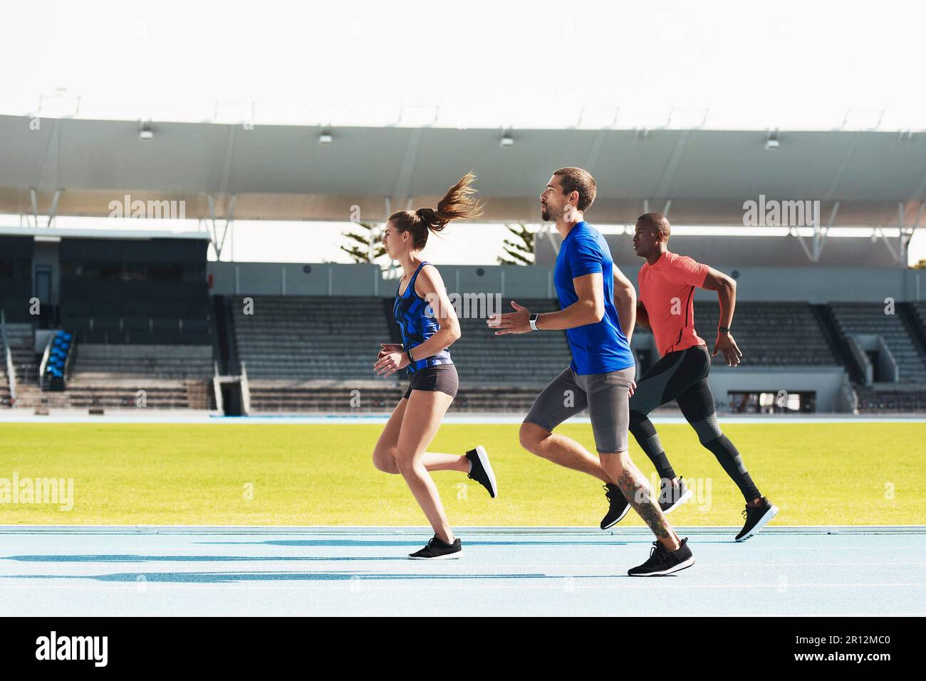 Full speed ahead. Full length shot of three young athletes running ...