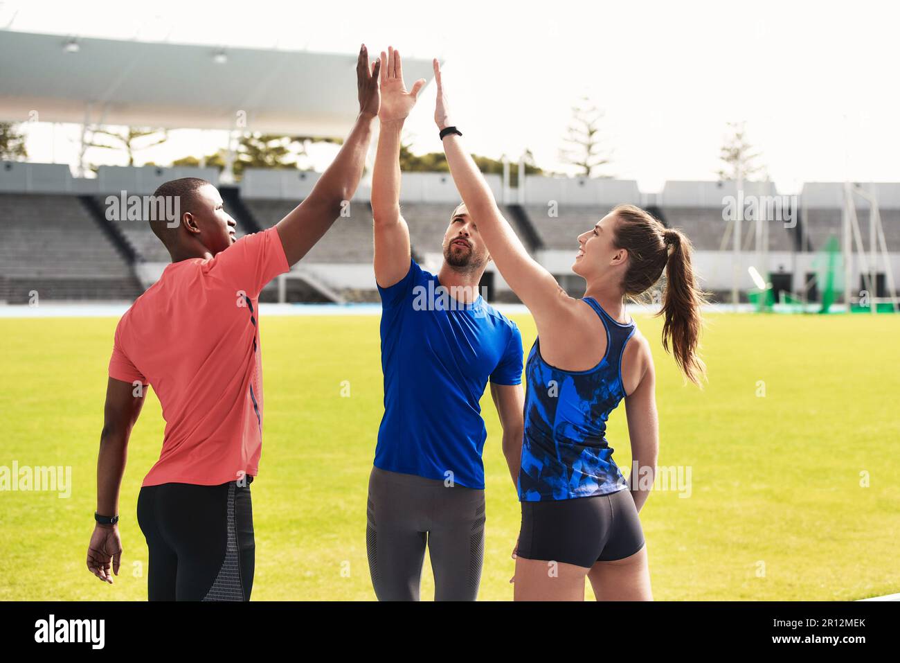 We did it. three young athletes high fiving after a workout on the ...