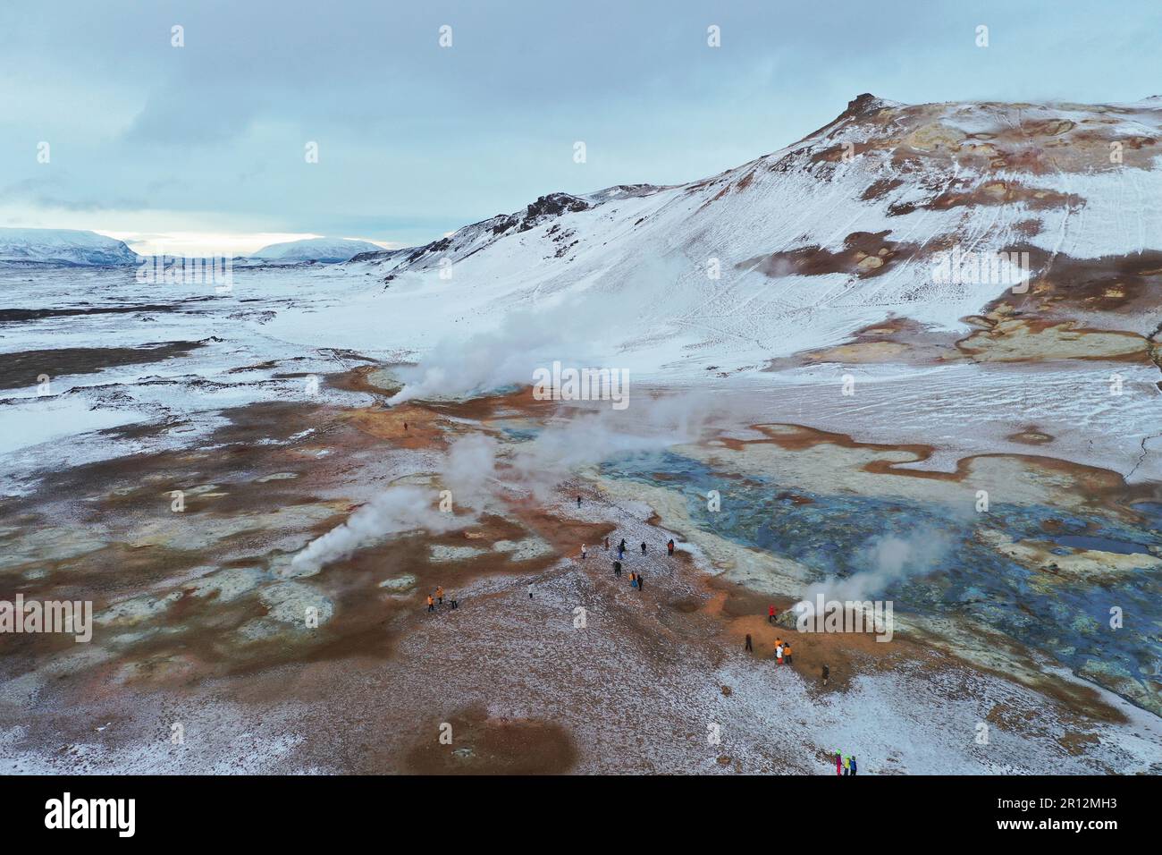 An aerial view of vibrant hot springs on a snowy mountain Stock Photo ...