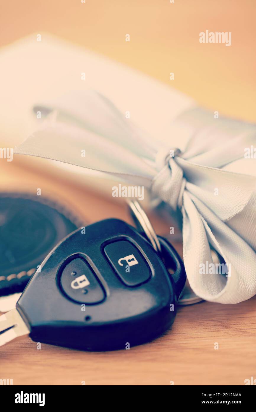 Ribbon, present and keys for new car on table for surprise, gifts and ...