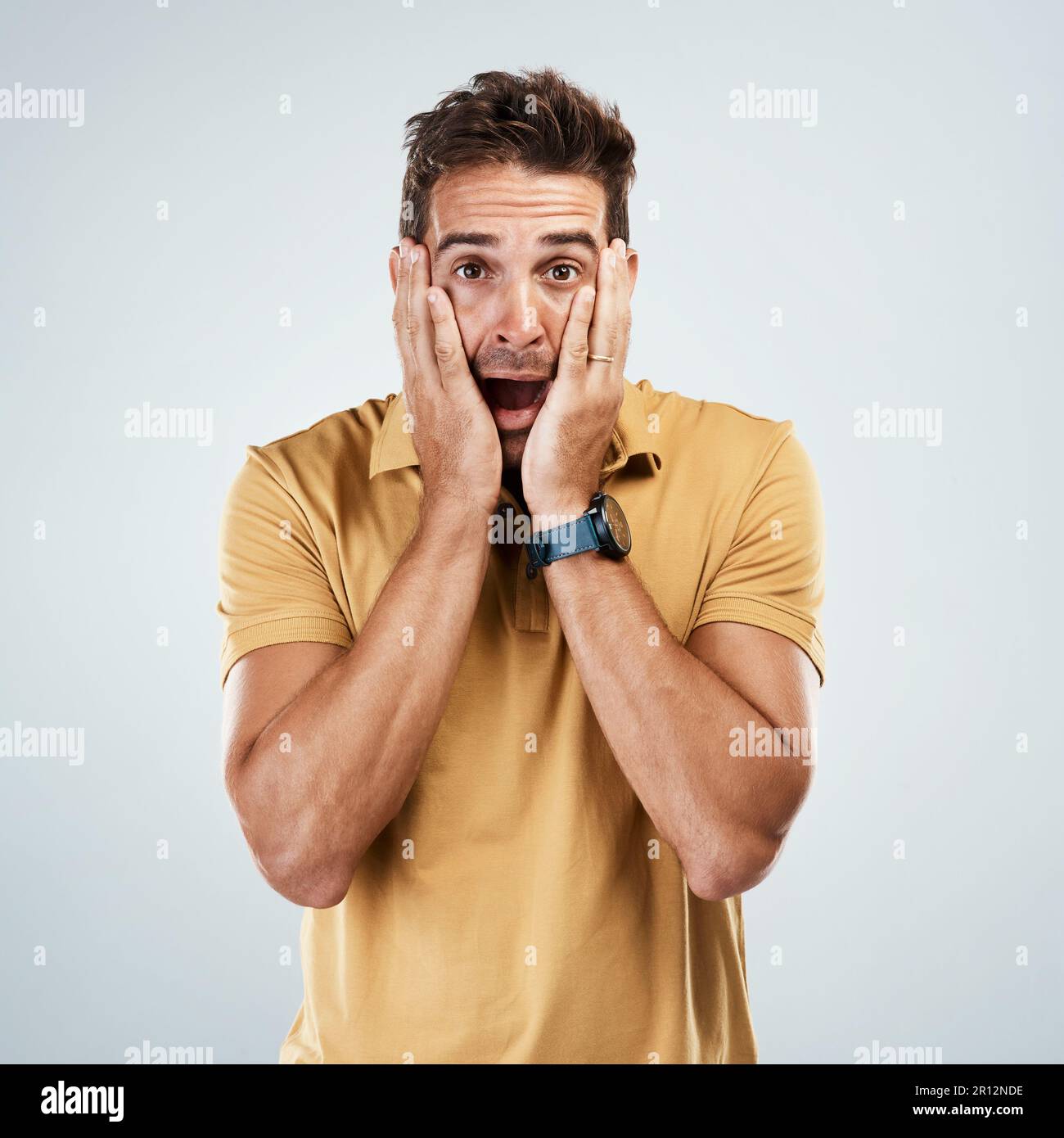 What have you done. Portrait of a young man with a scared facial expression while standing ...