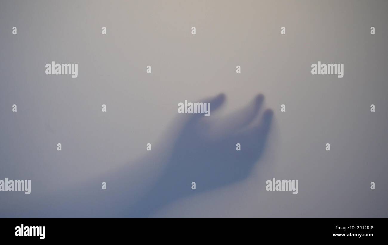 Shadow Blur of a horror man behind frosted glass. Blurred hand, body ...