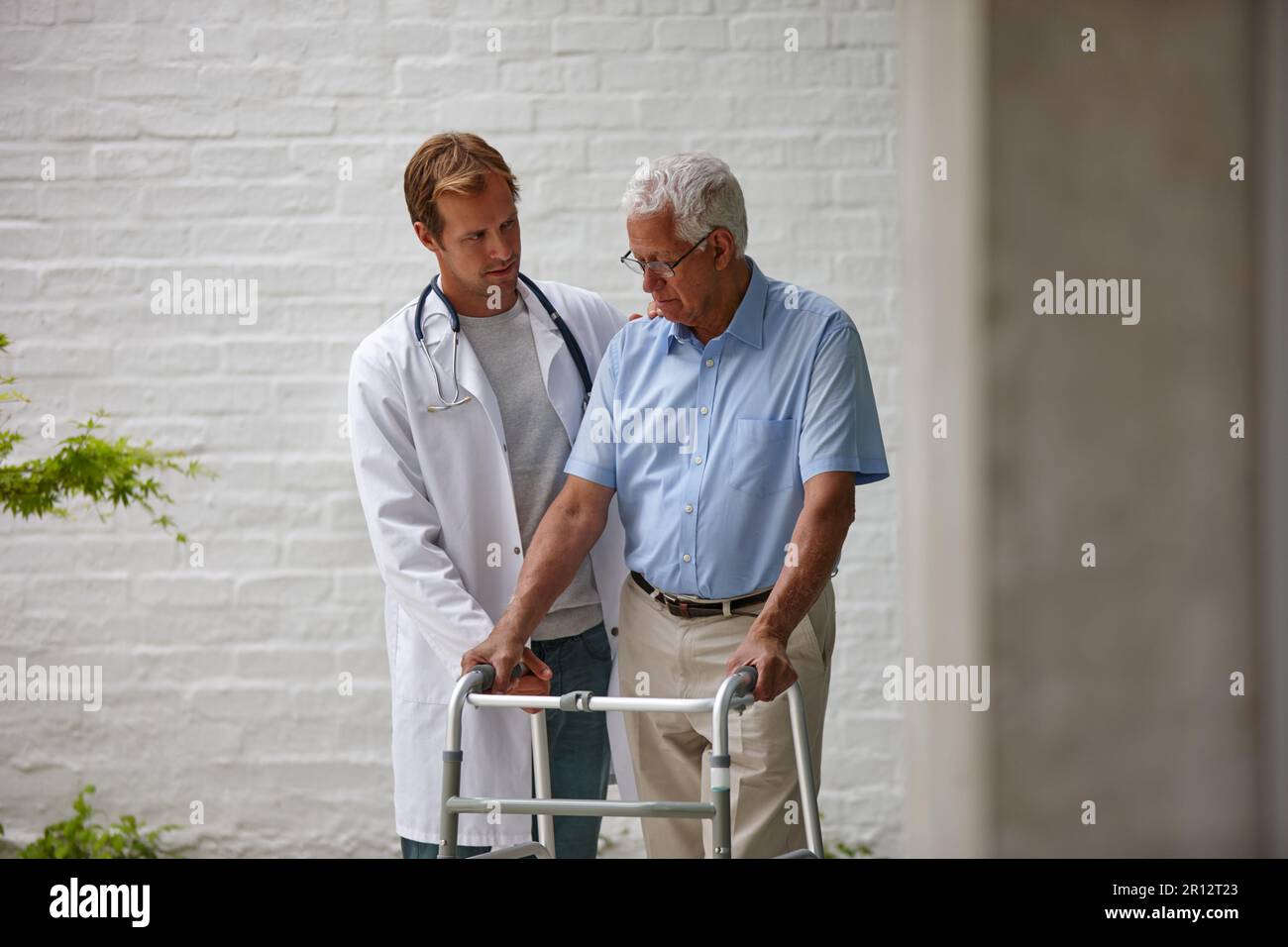 Remember to take it slow. a male doctor supporting his senior patient ...