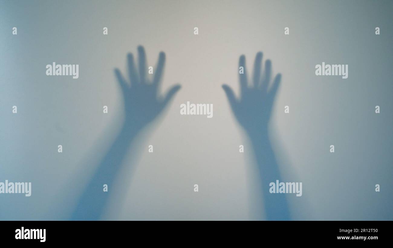 Shadow Blur of a horror man behind frosted glass. Blurred hand, body ...