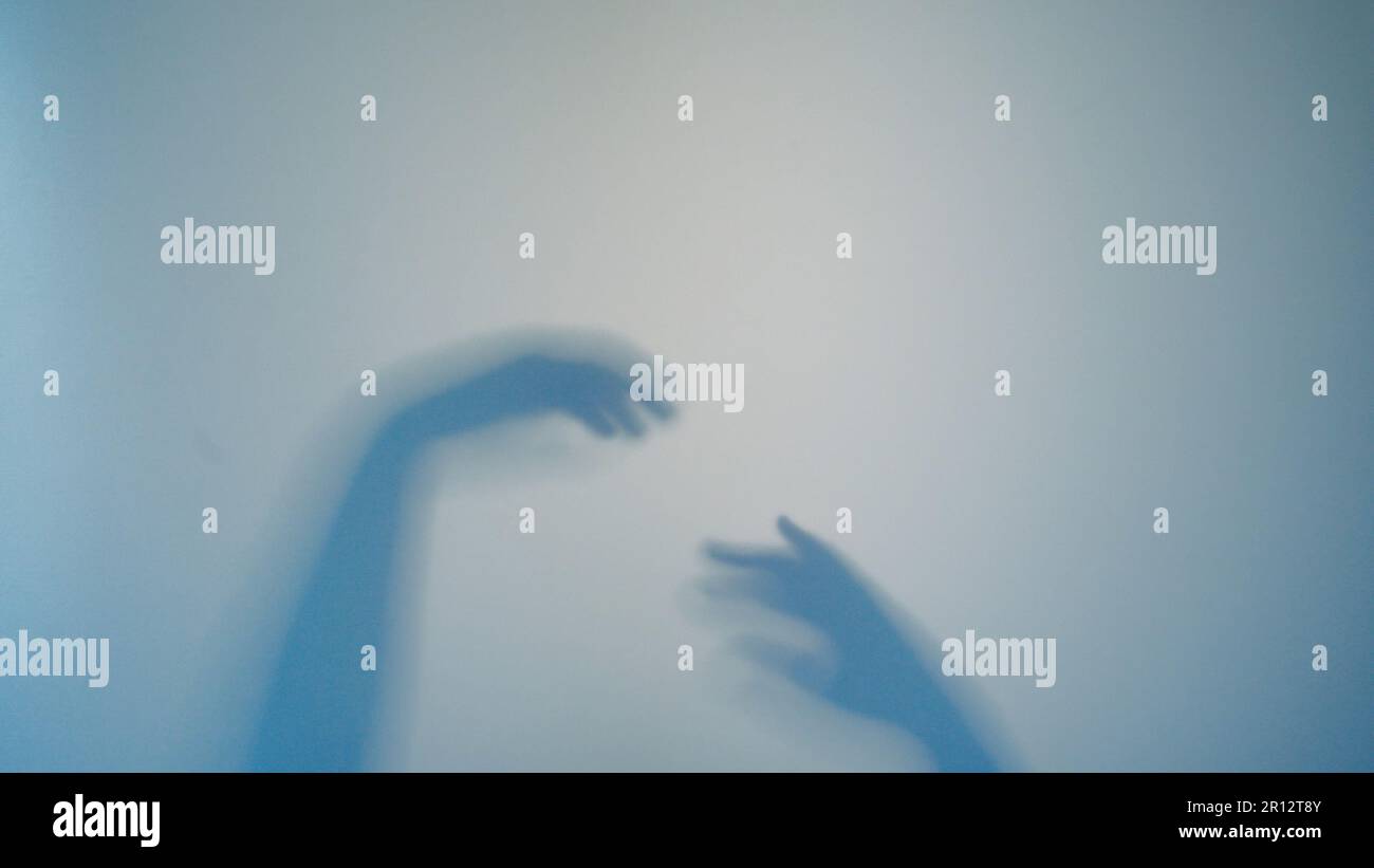 Shadow Blur of a horror man behind frosted glass. Blurred hand, body ...