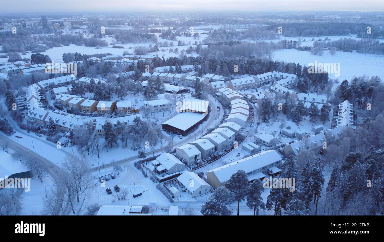 A winter scene of a small village with snow-covered buildings and trees ...