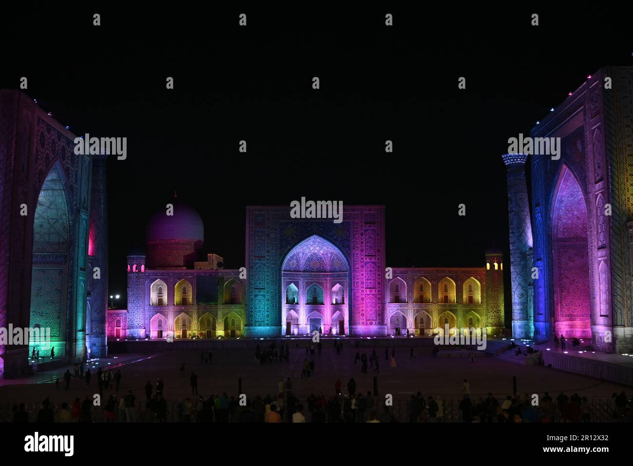 Night view of Registan square and its madrasahs with colorful lights in ...