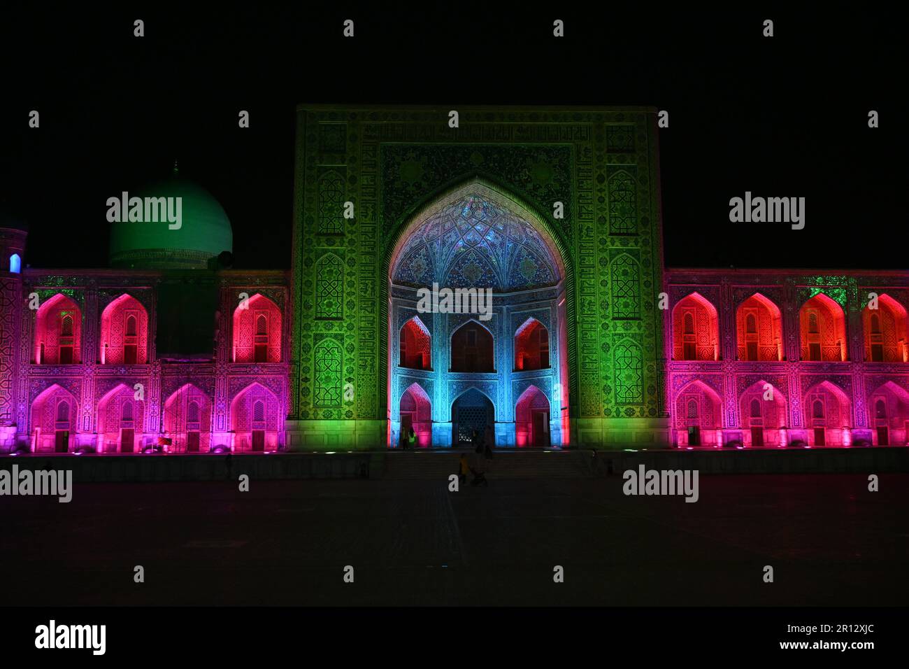 Night view of Registan square and its madrasahs with colorful lights in ...