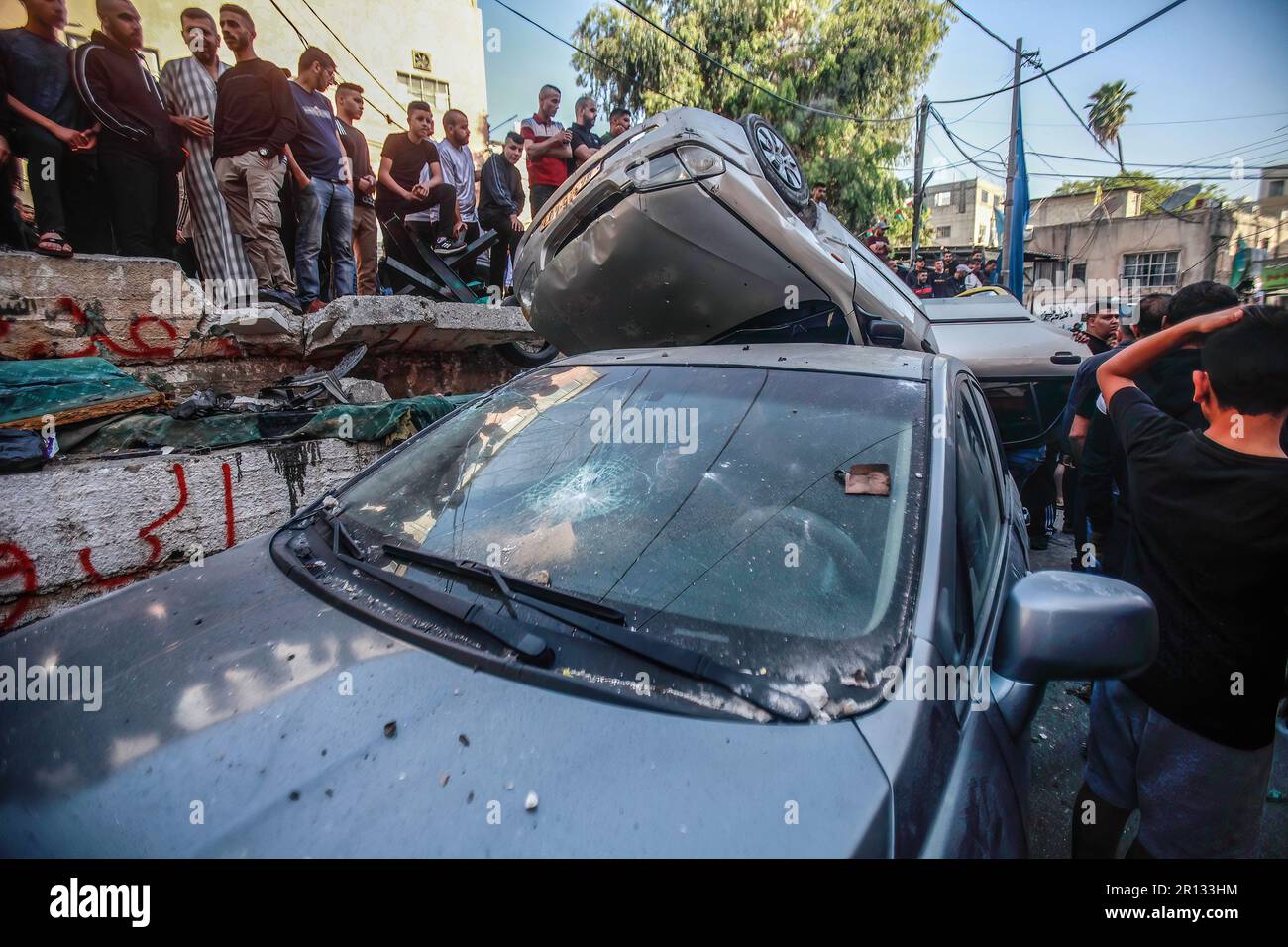 Palestinians remove destroyed vehicles and clean the streets from the ...