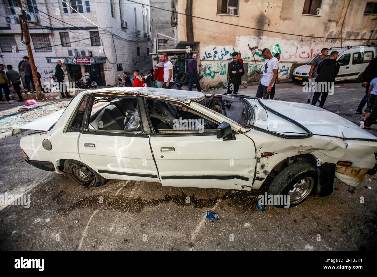 Palestinians inspect damaged vehicles following the Israeli forces ...