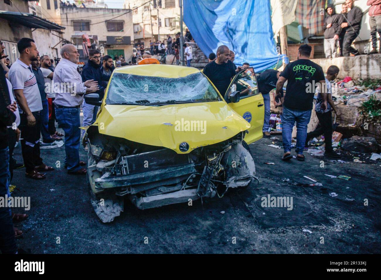 Palestinians inspect damaged vehicles following the Israeli forces ...