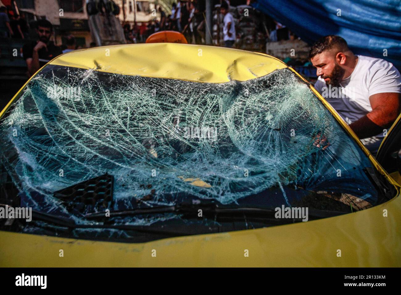 Palestinians inspect damaged vehicles following the Israeli forces ...