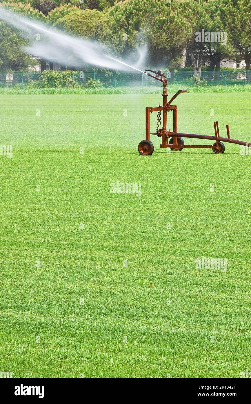 Metal irrigator in a green mowed lawn Stock Photo - Alamy