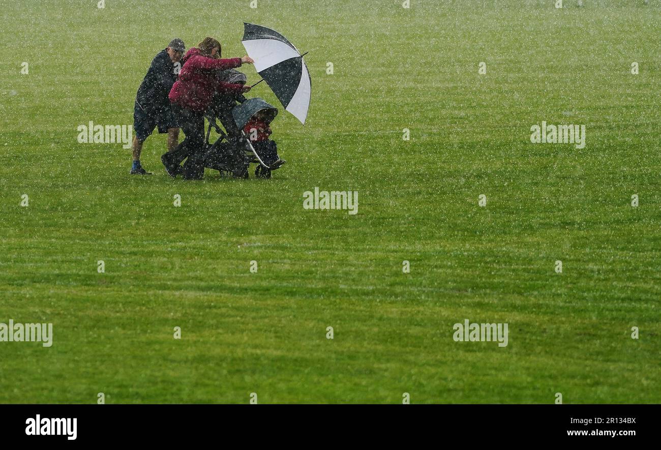 People seek shelter from a heavy rain shower in a park in Terenure ...