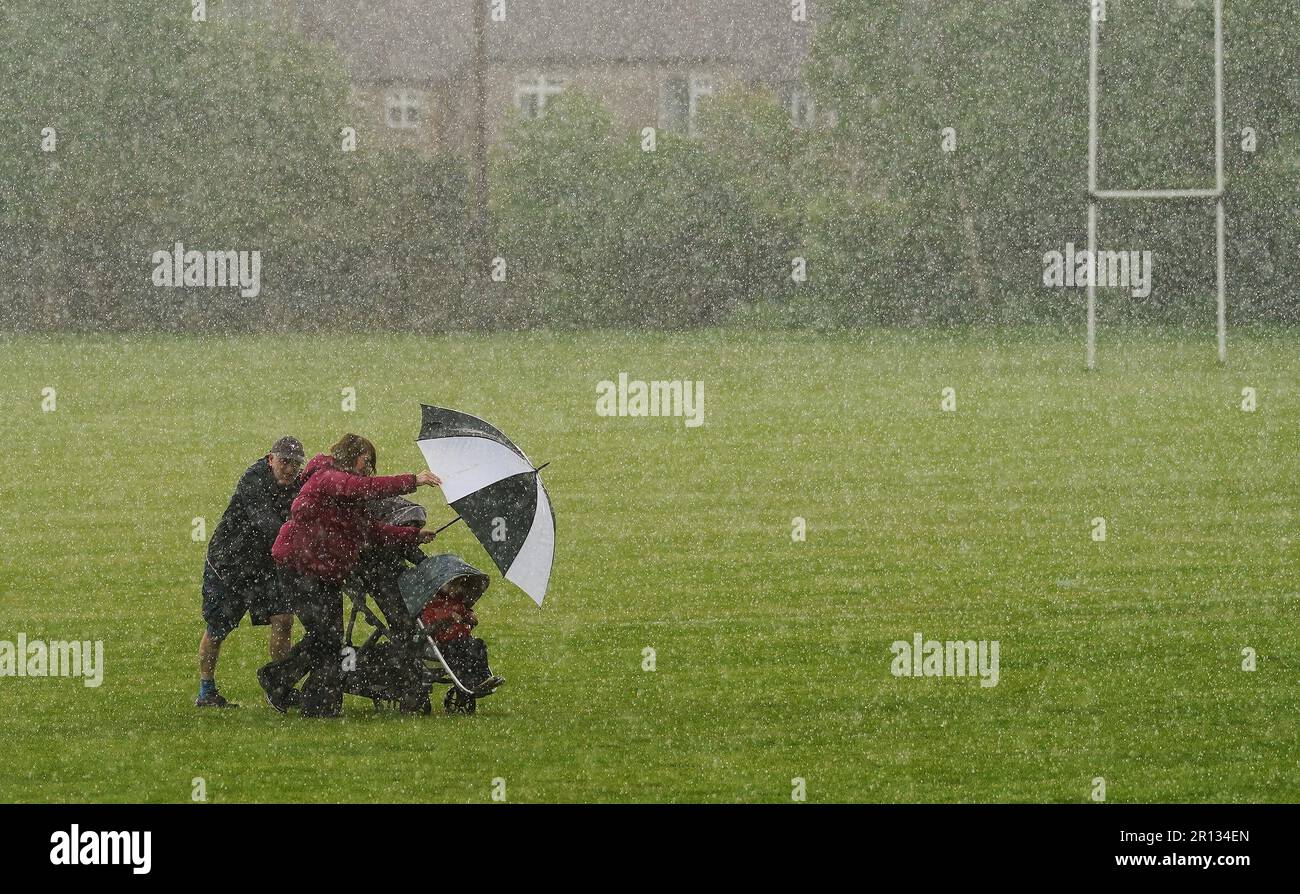 People seek shelter from a heavy rain shower in a park in Terenure ...