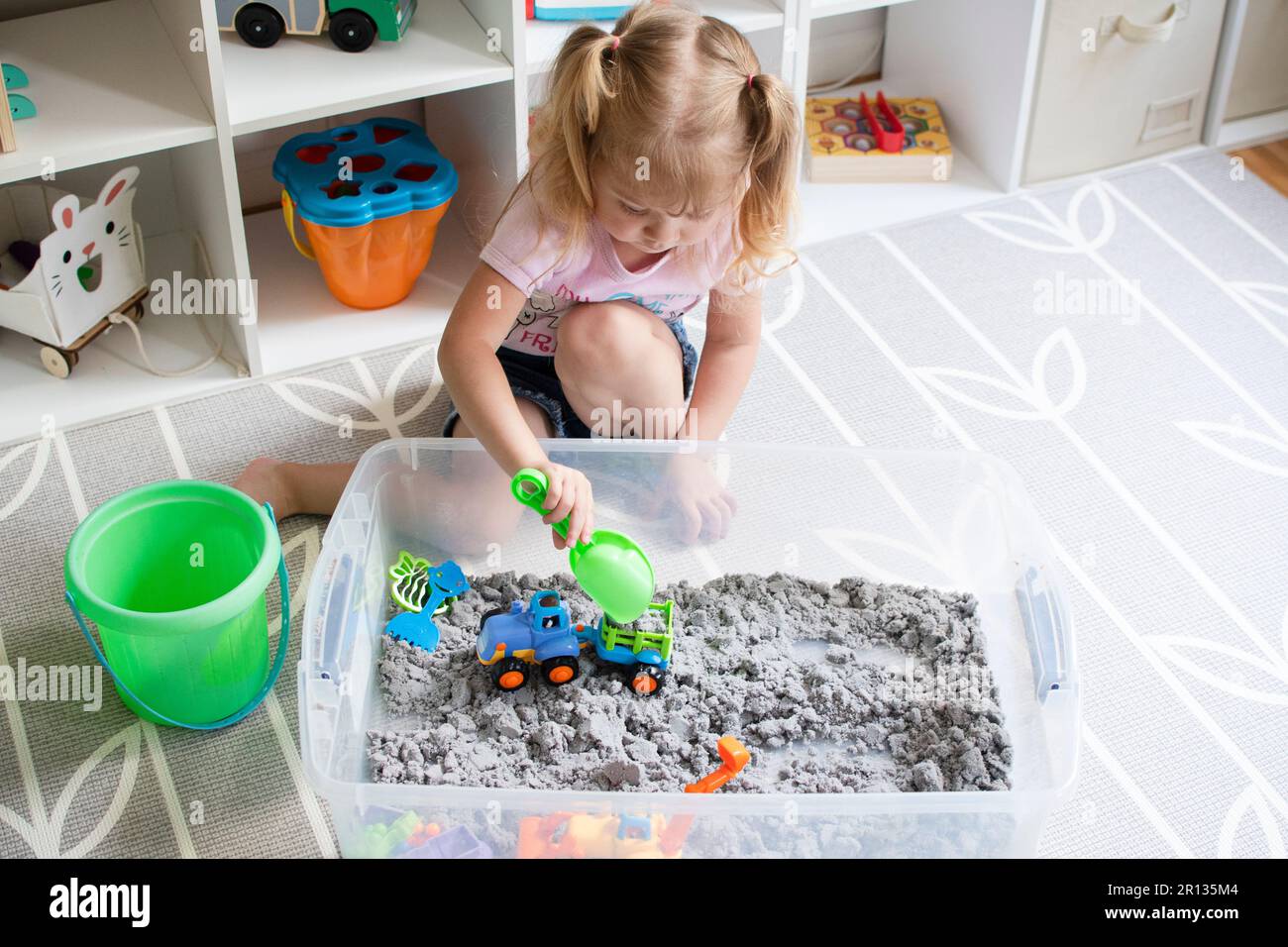 little girl playing with kinetic sand. Sensory box for kids Stock Photo ...