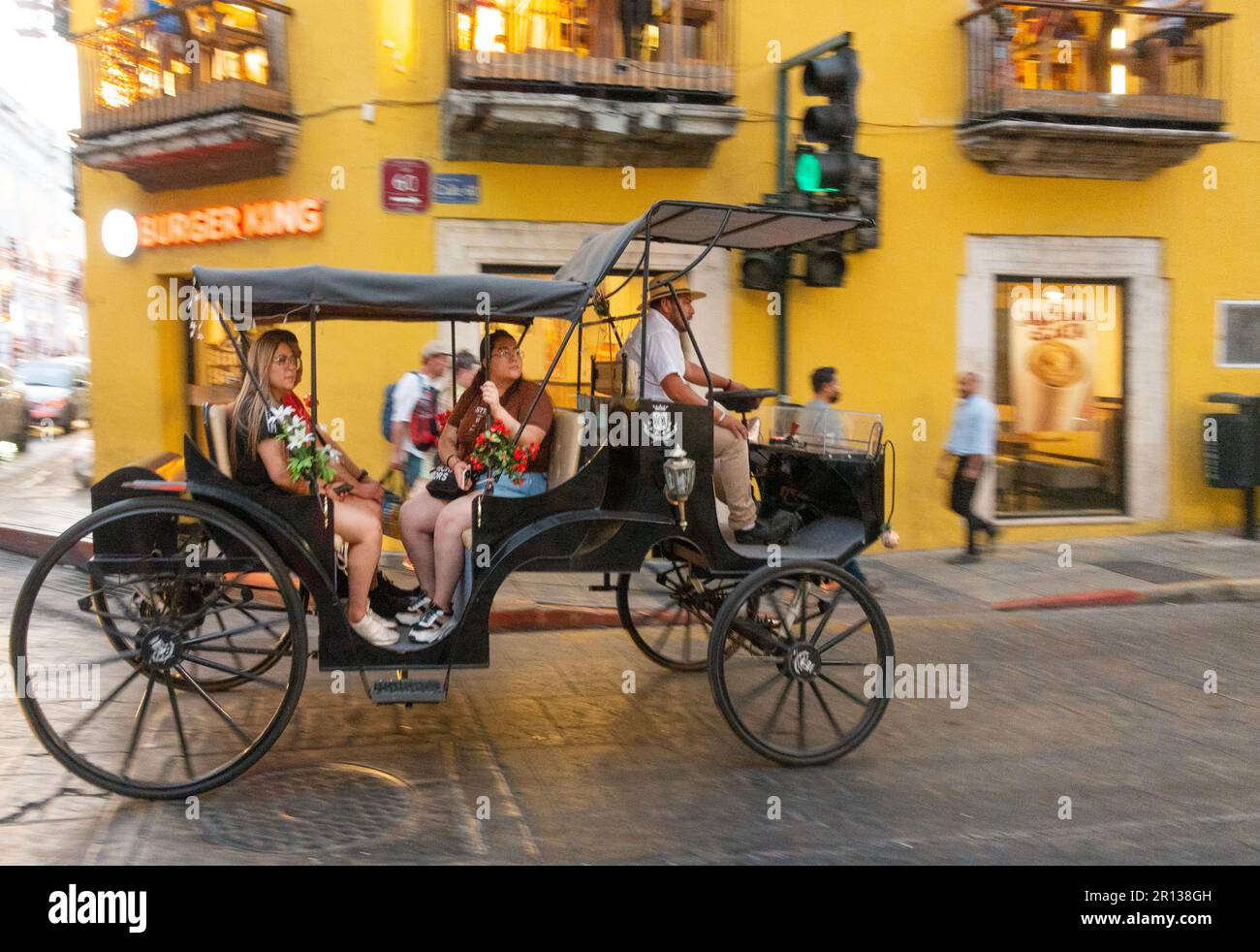 tourist riding a motorized carriage in front of Burger King in downtown ...