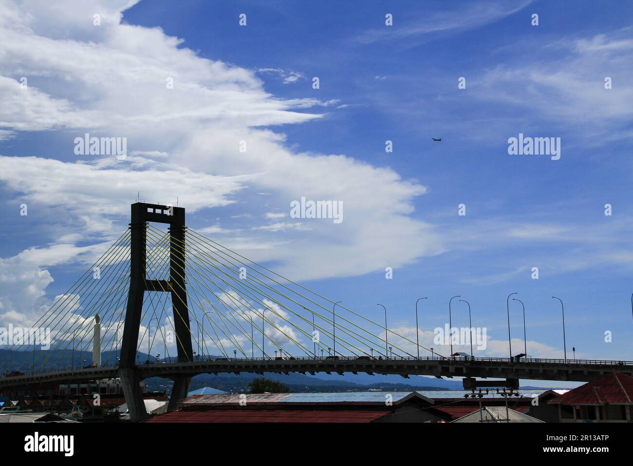 The bridge spans over the roof of the house with a blue sky as a ...