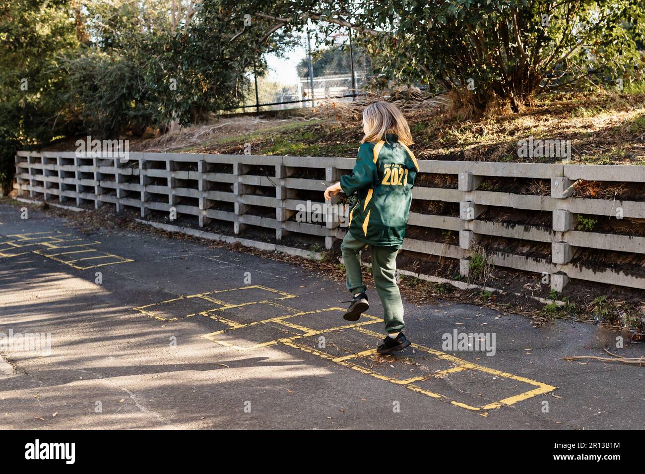 An Australian primary school girl playing hopscotch in the school yard ...