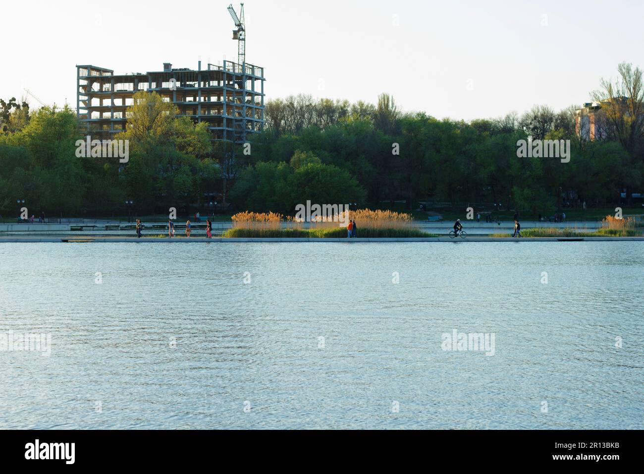 Сonstruction of a multi-storey building in park area, where people walk ...