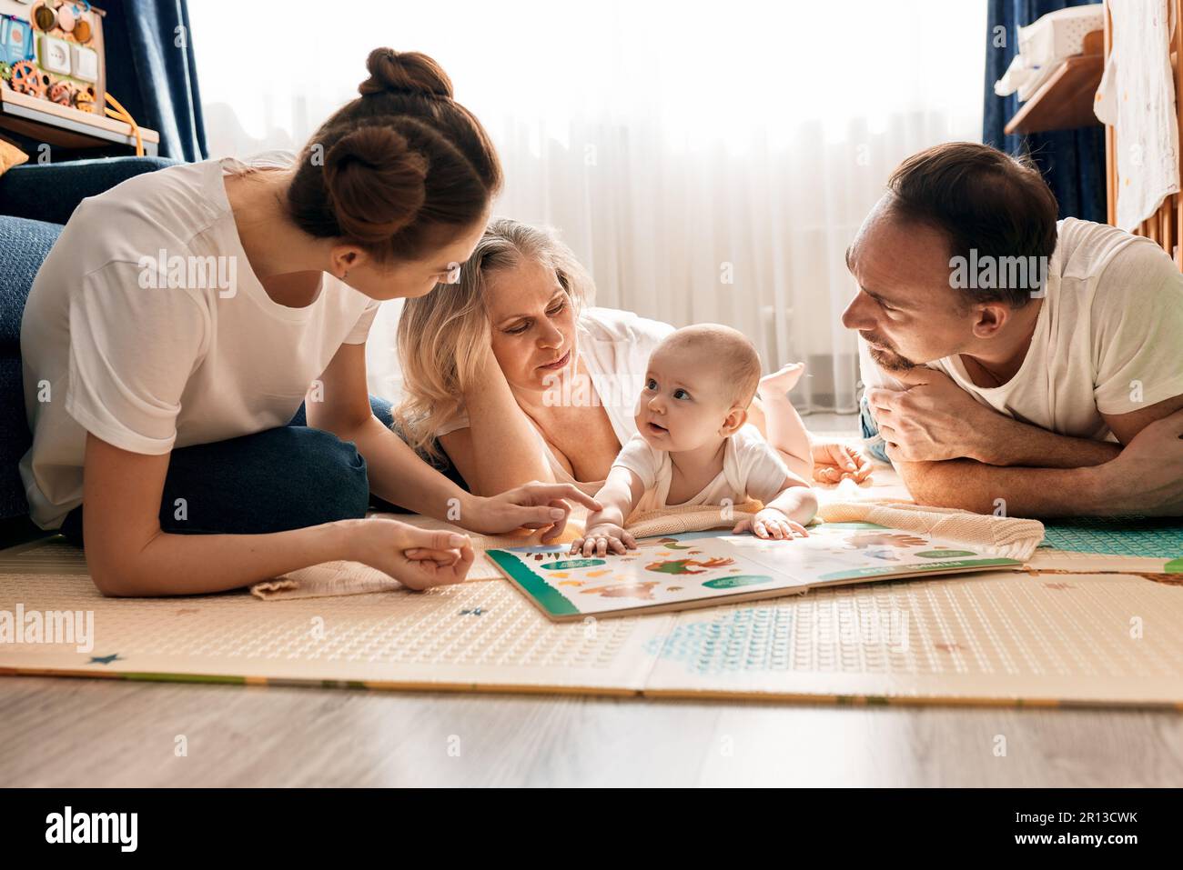 Parents together with their child play and study a children's book ...