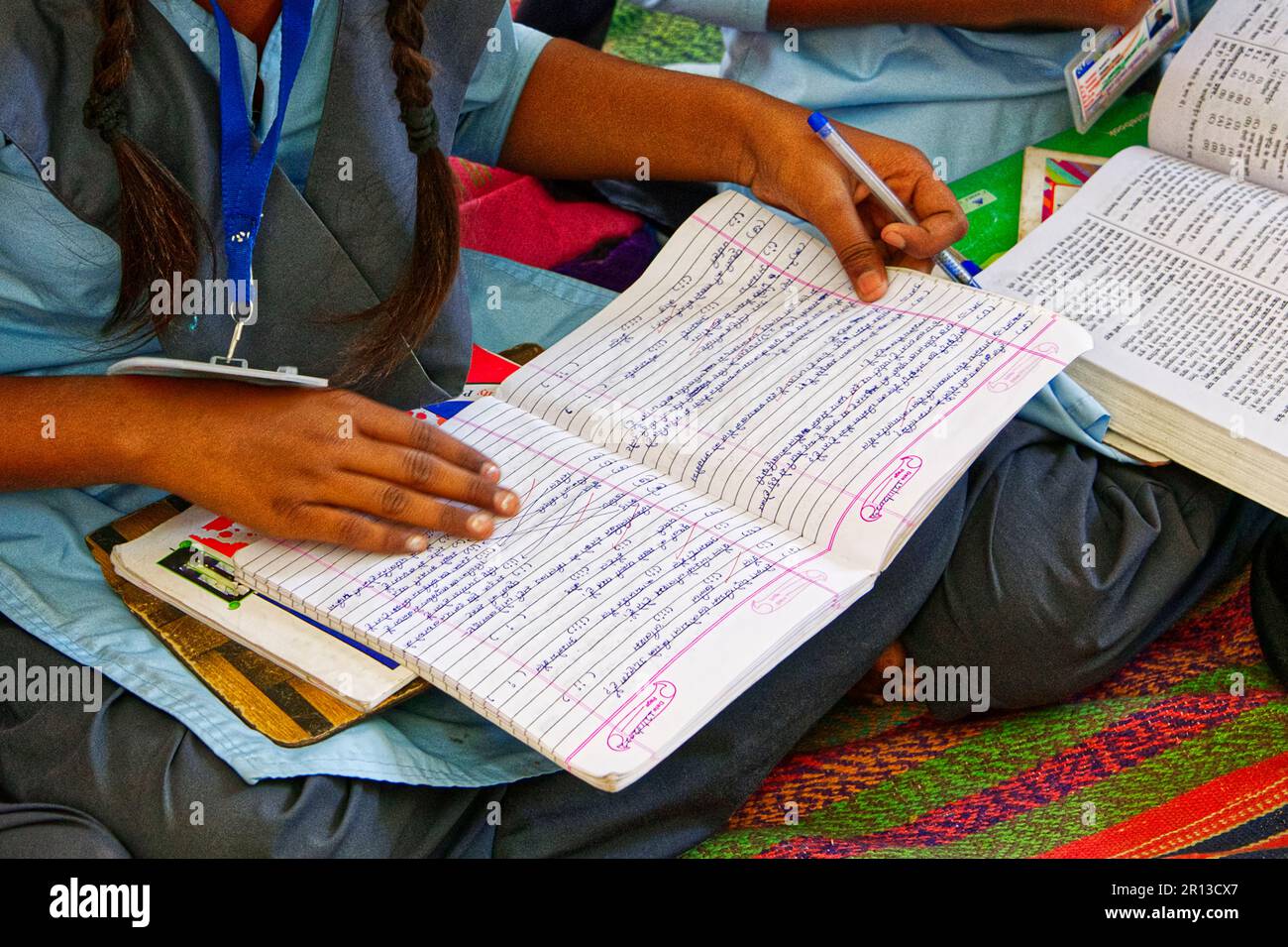 Children in the school are sitting on the floor and have the books and ...