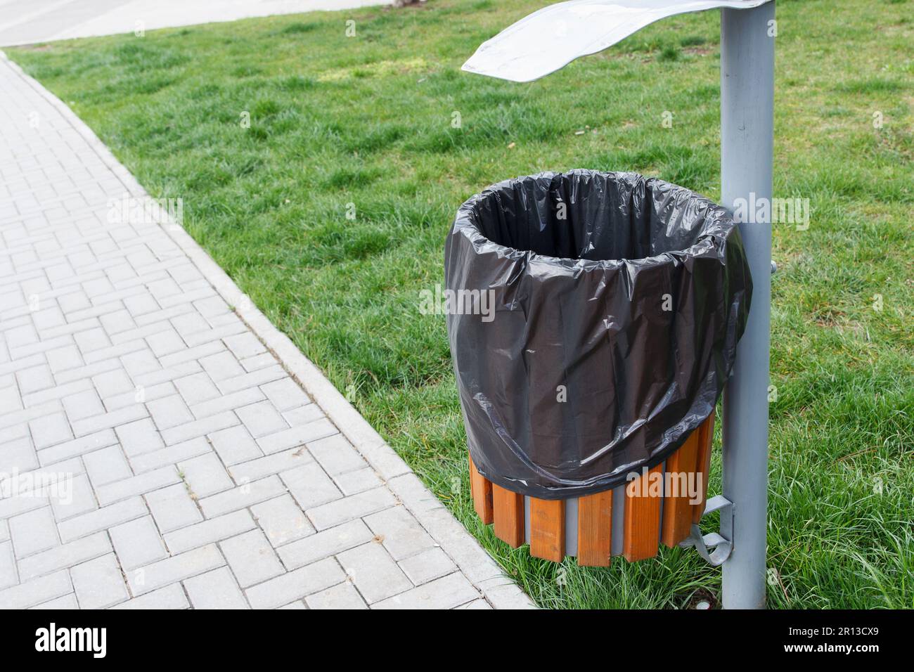 A garbage bin with a garbage bag is installed in a public place, a park ...