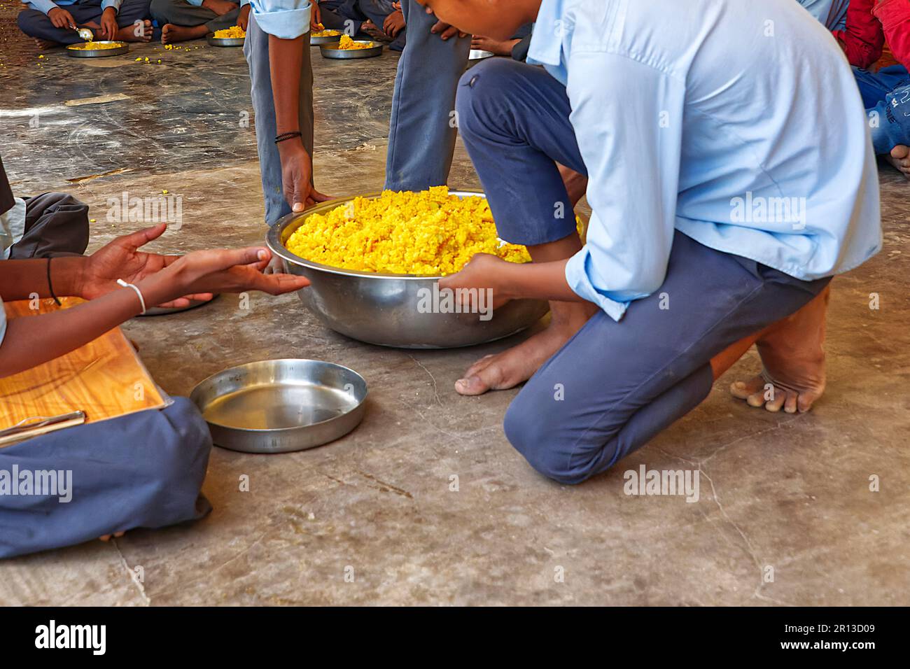 Schoolboy in uniform shares the food for the lunch to his camarades ...