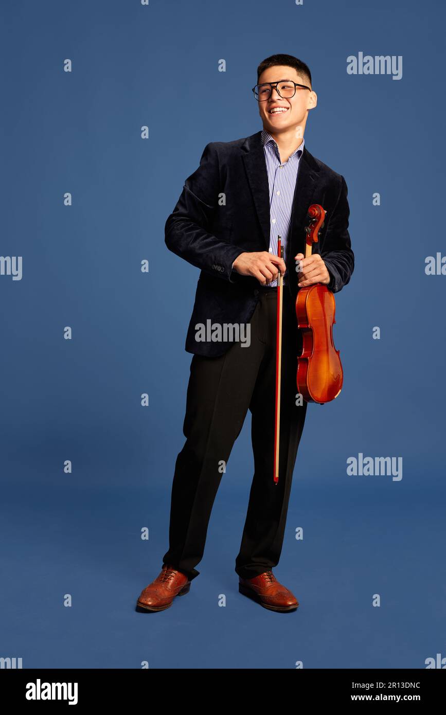 Portrait with stunning, young musicians, violinist wearing elegant suit ...