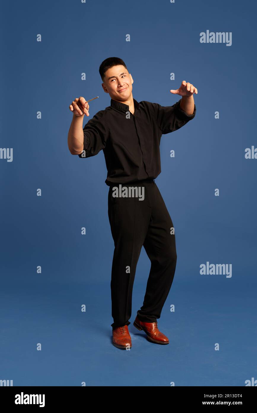 Portrait with musician, conductor wearing black costume holding ...