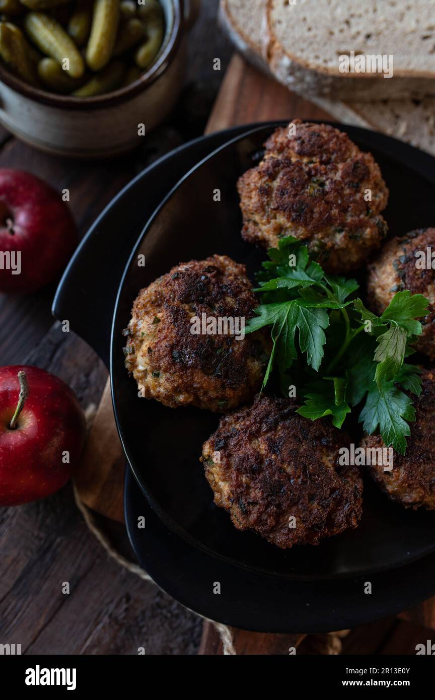 Rustic bread meal with warm pork meatballs, pickles and rye bread on ...
