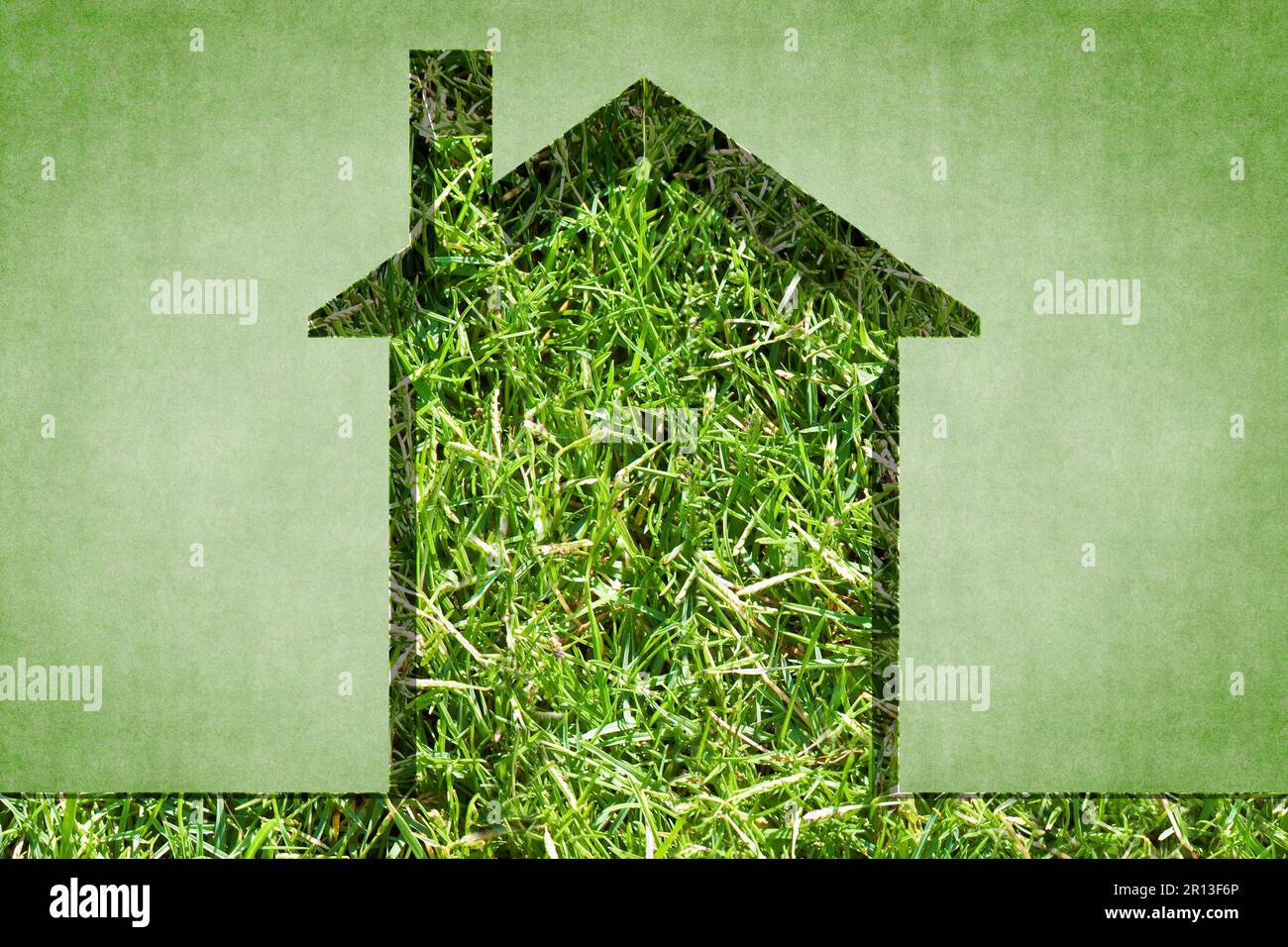 Concept of ecological house with an house outline against a green grass ...