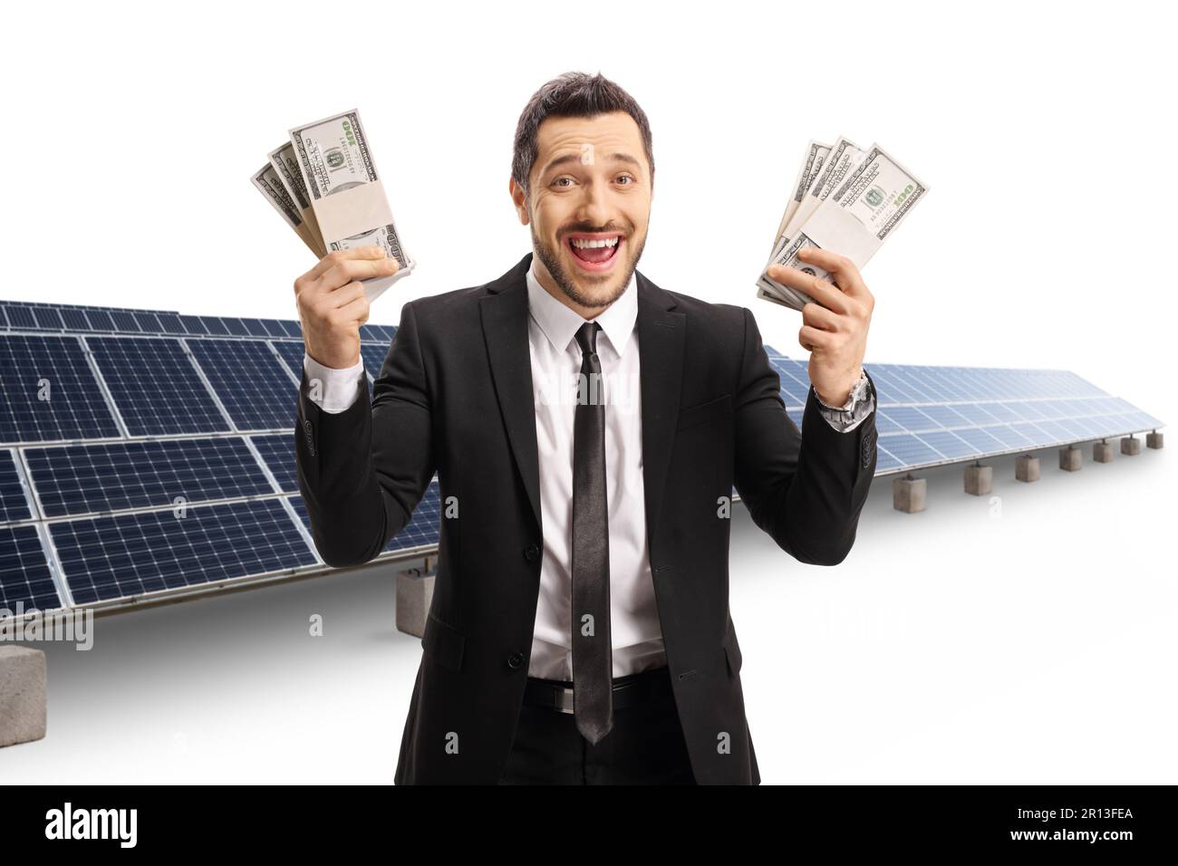 Businessman holding stacks of cash in both hands in front of solar ...