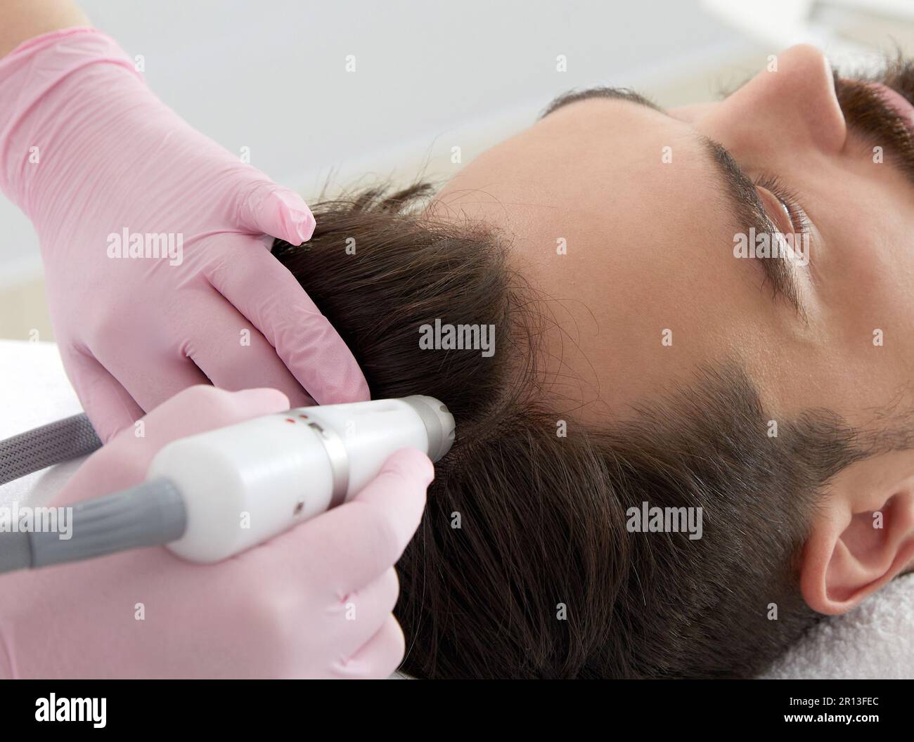 Doctor female dermatologist trichologist makes a procedure to stimulate ...