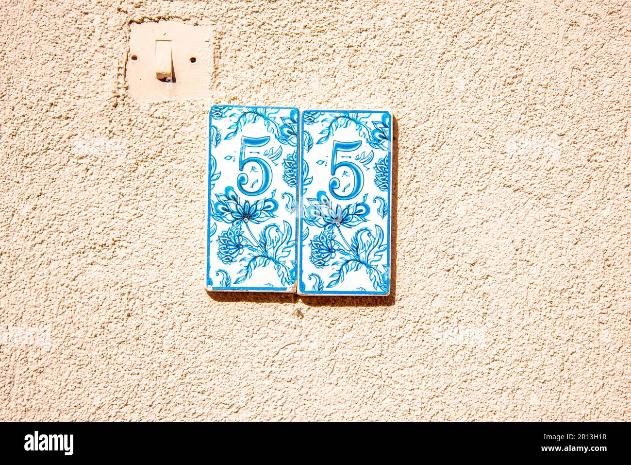 Number plate 55, blue color plate on beige wall. House numbering Stock ...