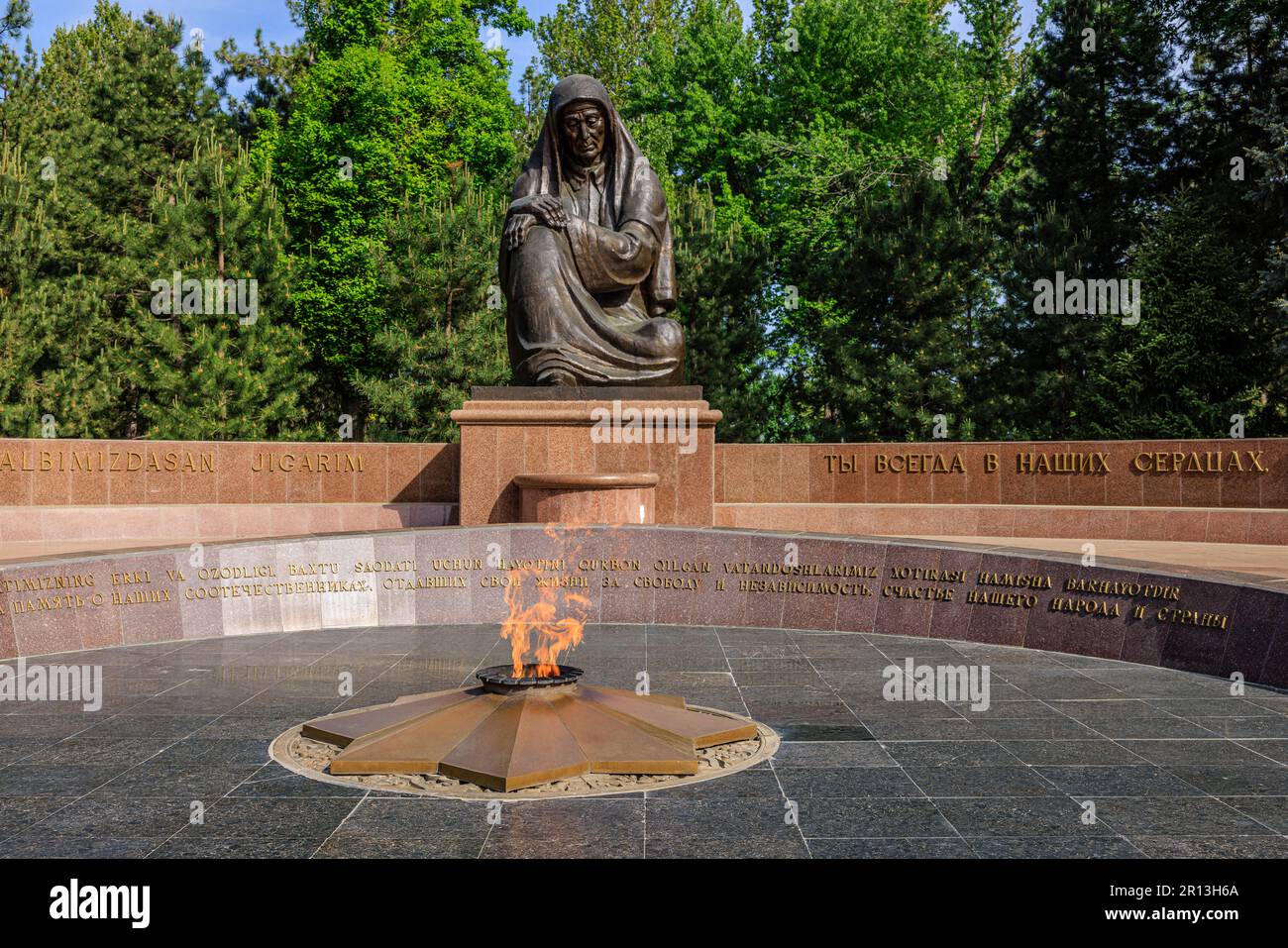 the eternal flame burns in front of the crying mother statue at the ...