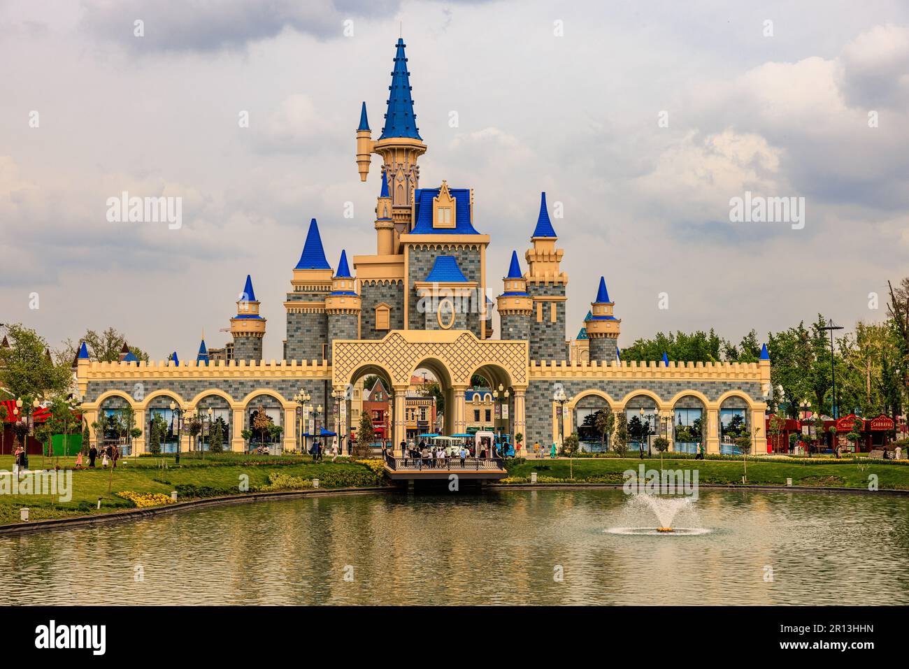 a fairytale palace with blue turrets on the shore of a lake with ...