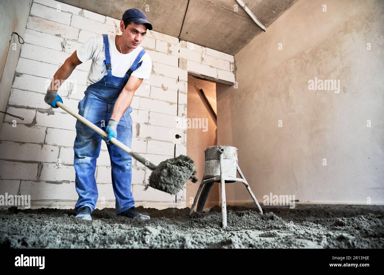 Man preparing floor screed material while standing near concrete screed ...