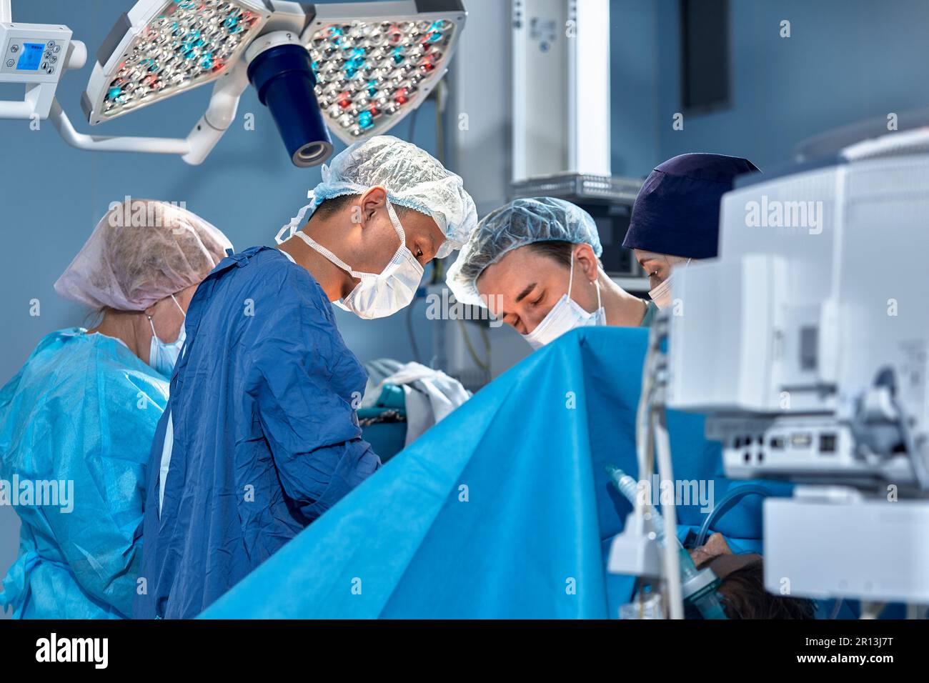 The team of surgeons in the operating room bent over the patient ...