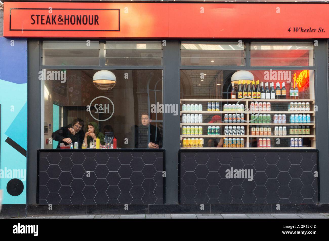 People enjoying their meals can be seen through the window of Steak and ...
