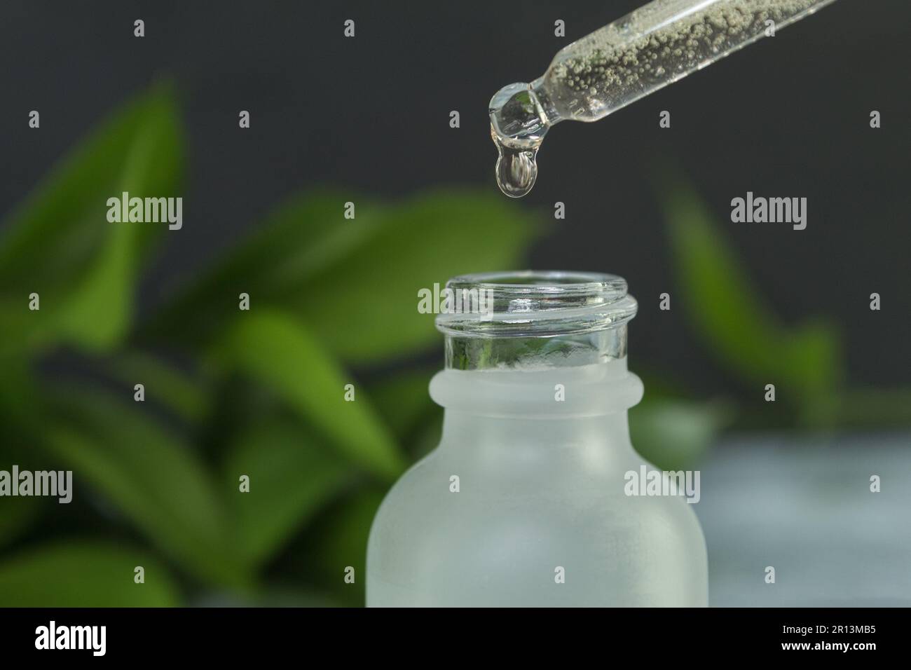 A drop of oil flows from the pipette. It drips into the neck of the ...