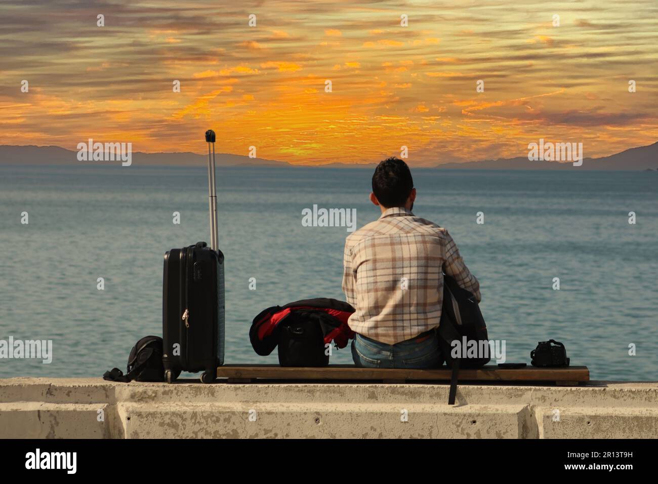 man sitting on bench with suitcase. Sad man feeling lonely, sitting on ...