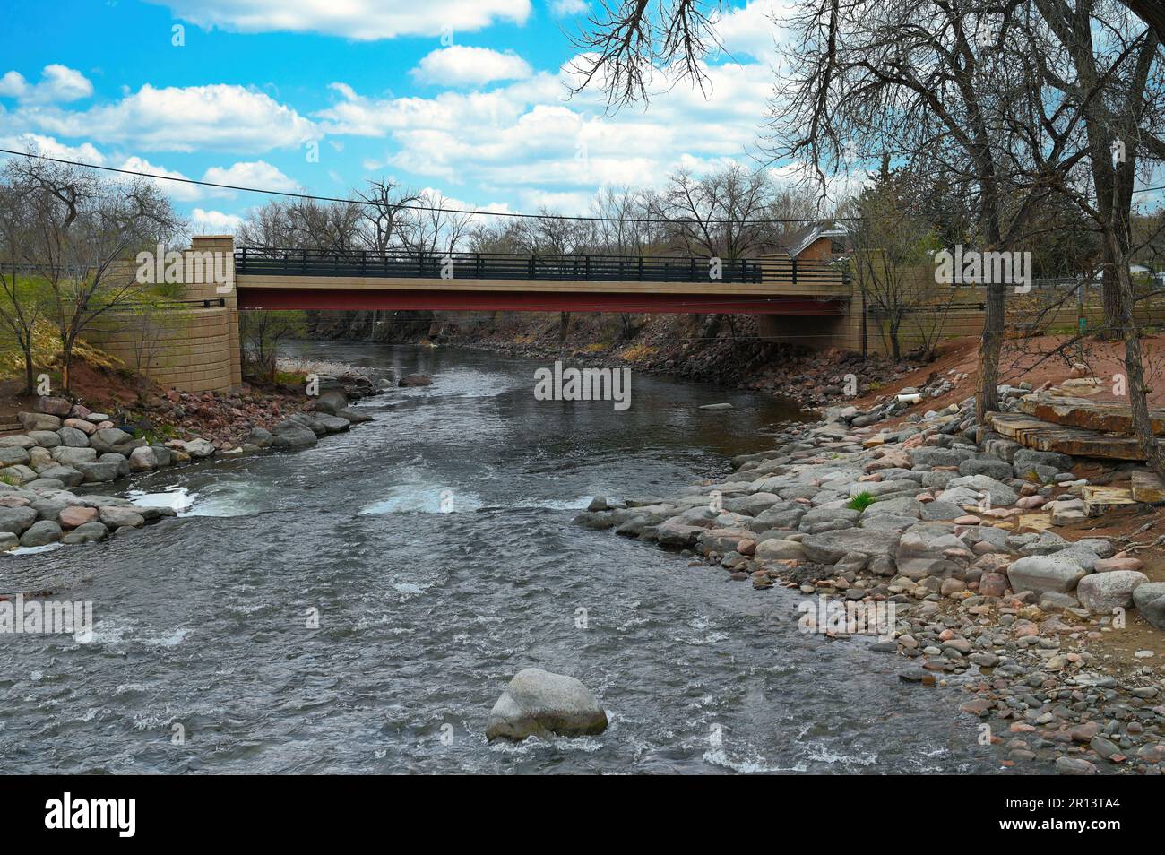 A Red Bridge Crossing Over a Rapid Flowing River Stock Photo - Alamy