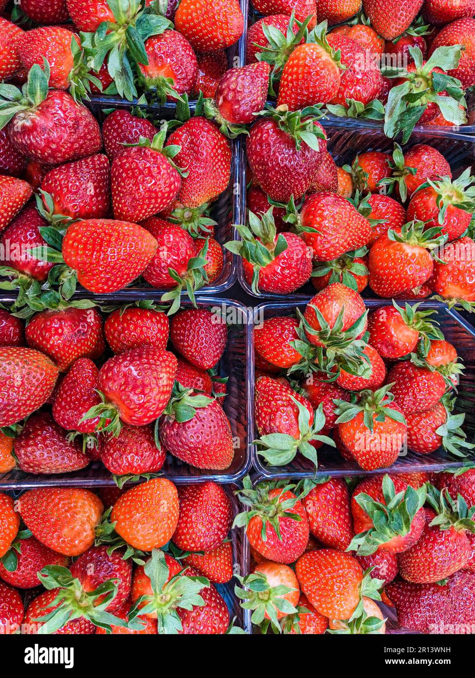 A lot of different strawberries in plastic trays in the supermarket ...