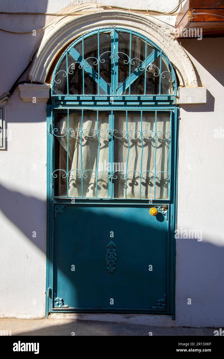 A green Turkish-style metal door with a white wall. Concept ...