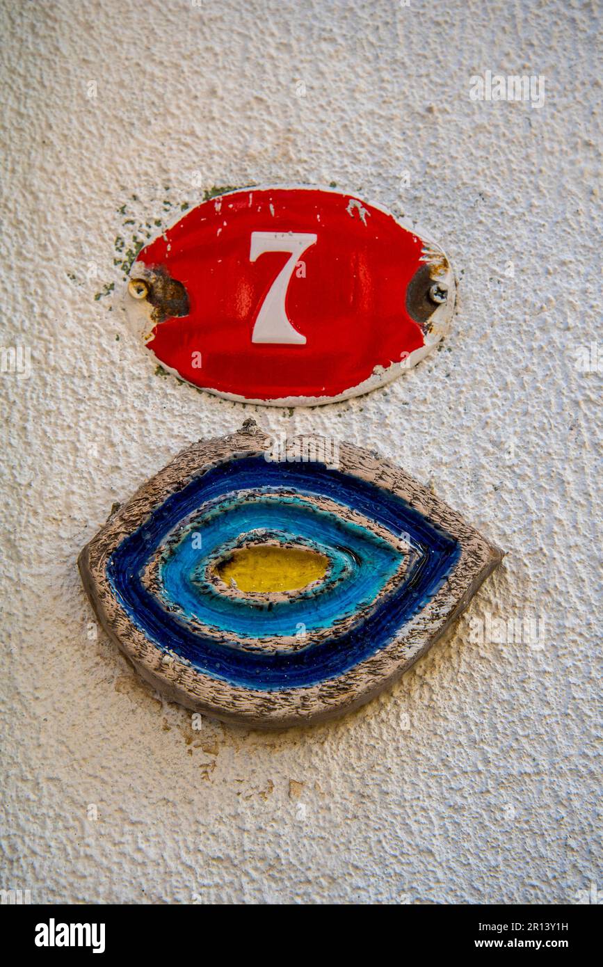 A sign with the number 7 in red on a white wall. The concept of ...