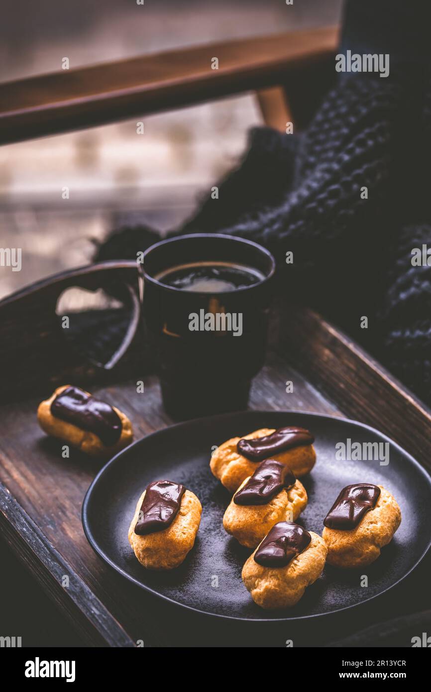 Wooden tray with mini eclairs and coffee on a wooden tray on an ...