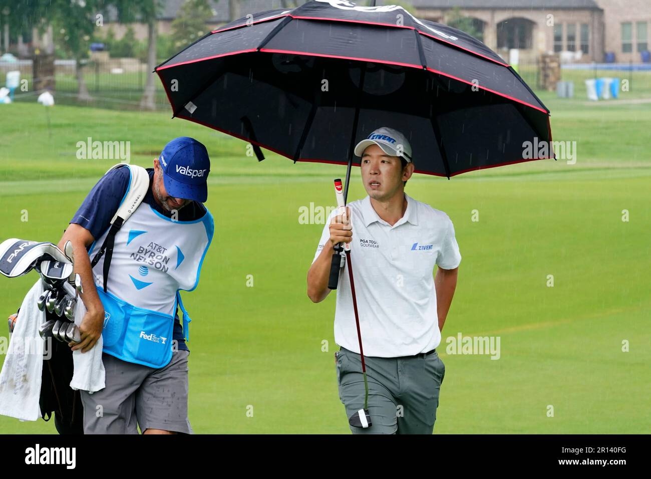 S.Y. Noh, of South Korea, uses an umbrella to keep dry during the first ...