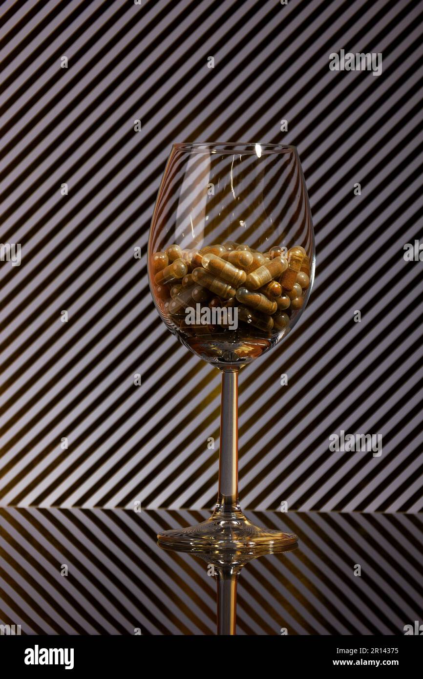 close up of a wineglass filled with capsules and a background with ...